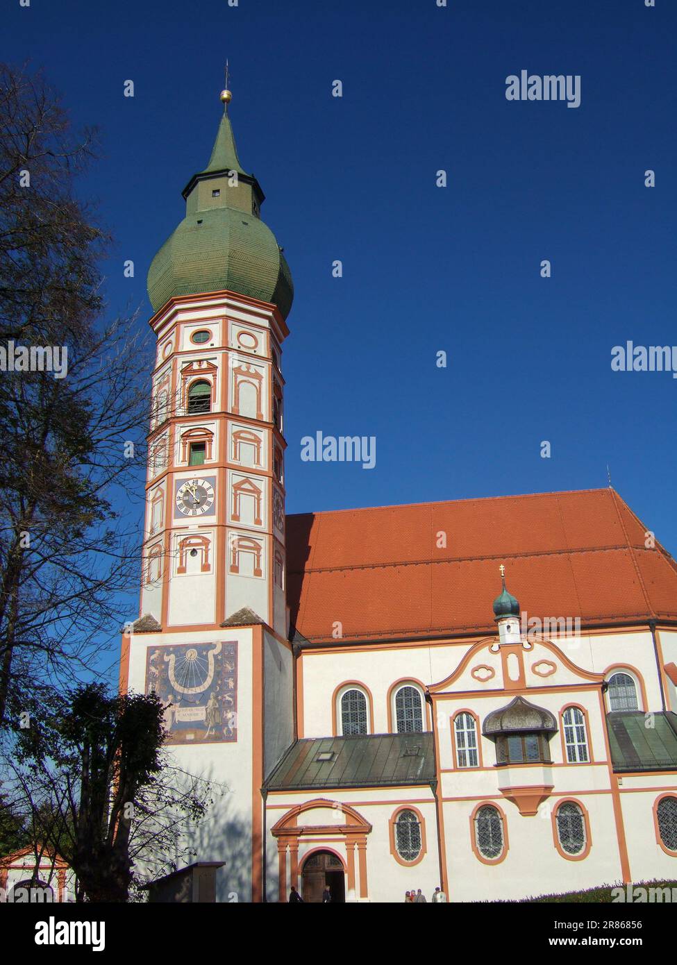 Red and white monastery church with green domed tower roof in Andechs ...
