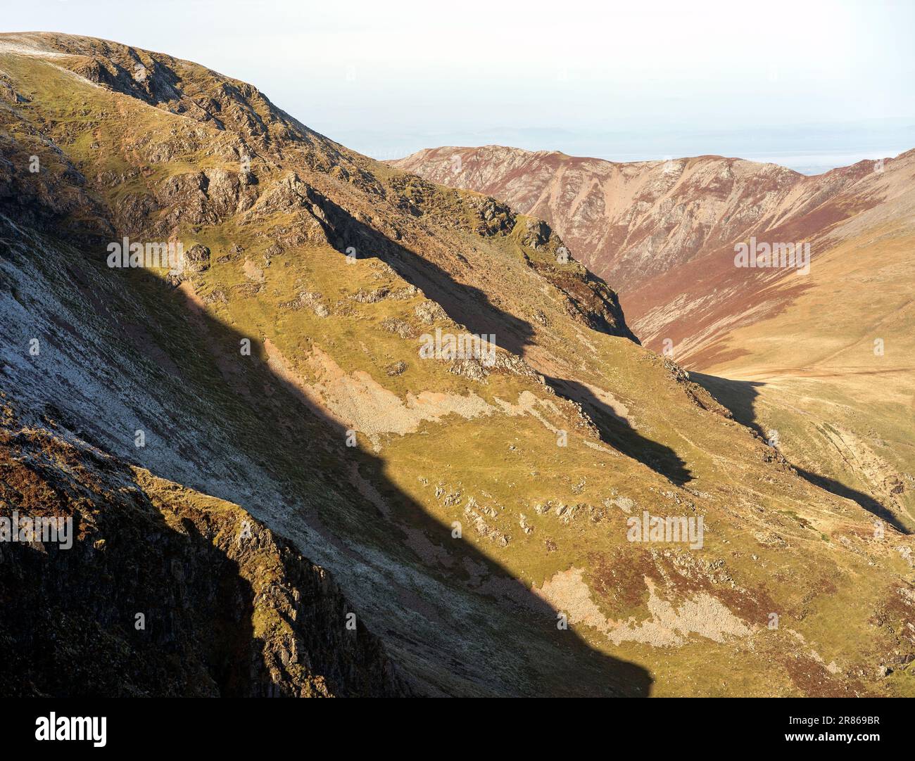 The steep cliffs below the summit of Crag Hill in winter in the English ...
