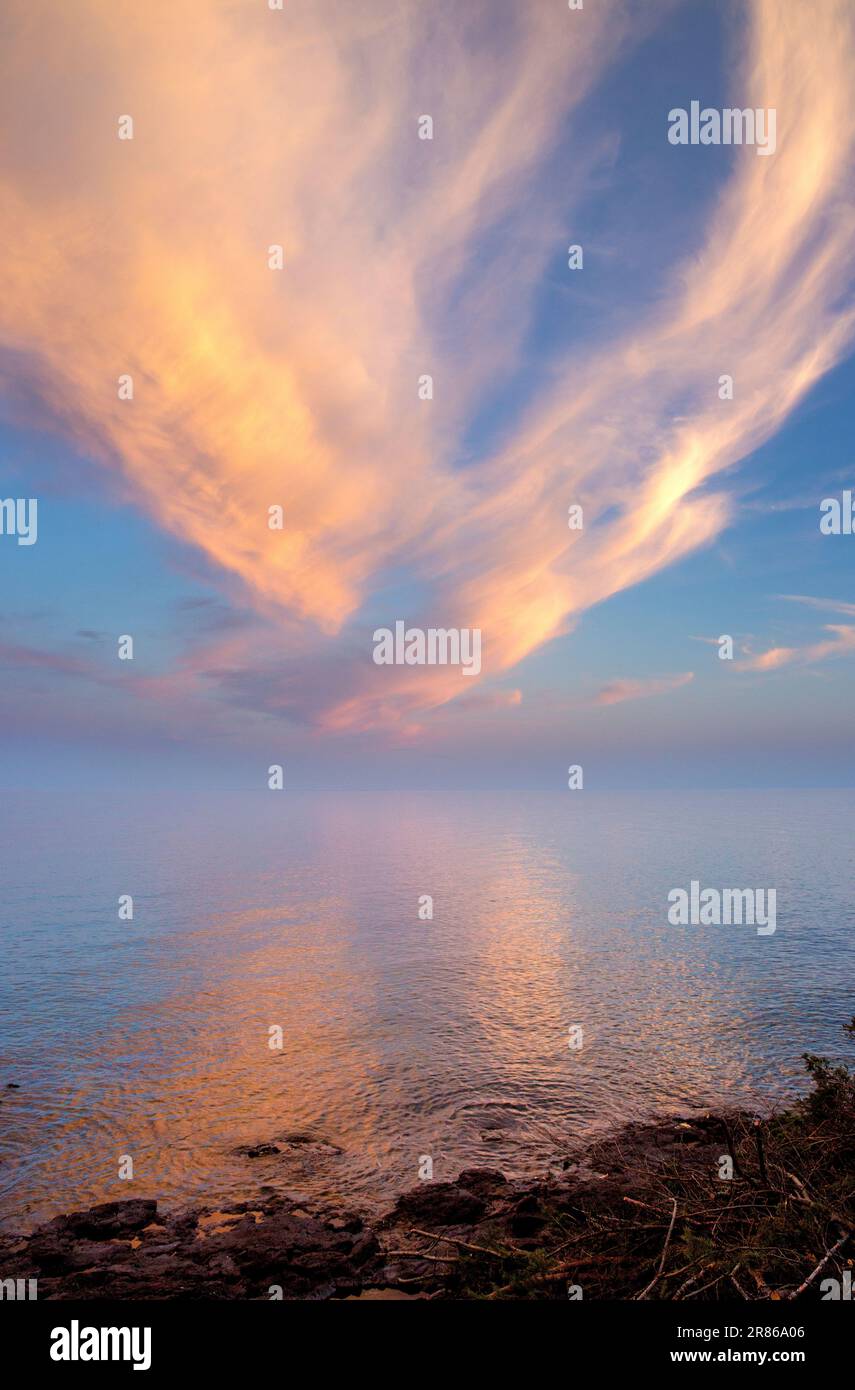 Complementary colors of orange cirrus clouds with blue sky and water at ...