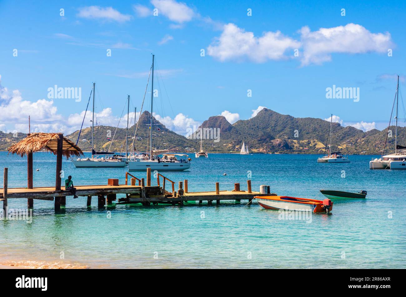 Lagoon with turquoise waters, yachts and boats at Mayreau island pier ...