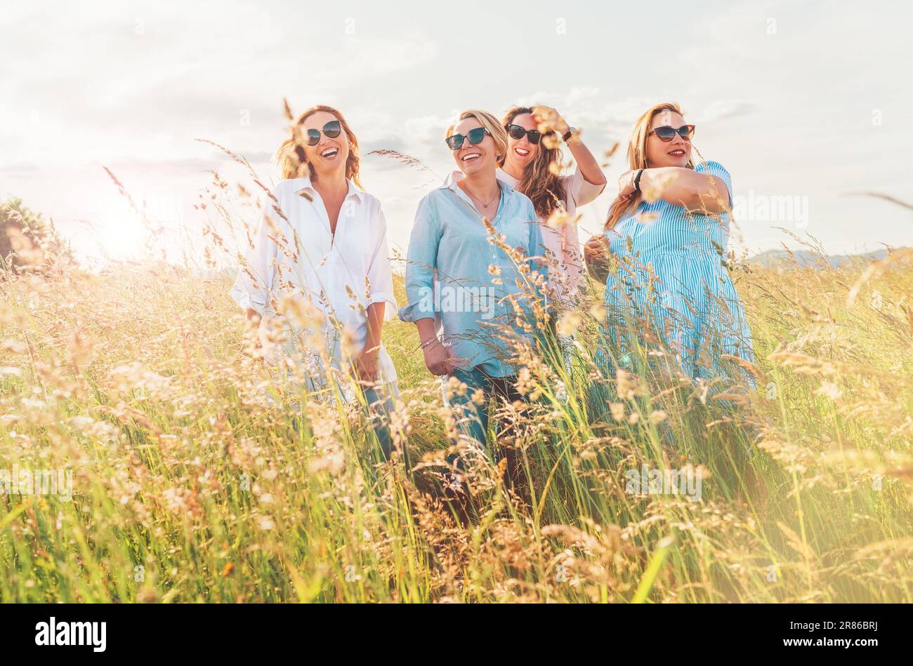 Portrait of four cheerful smiling and laughing women during outdoor ...