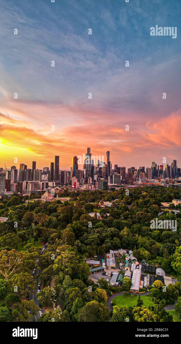 A vertical aerial view of a bright sunset sky over the skyline of ...