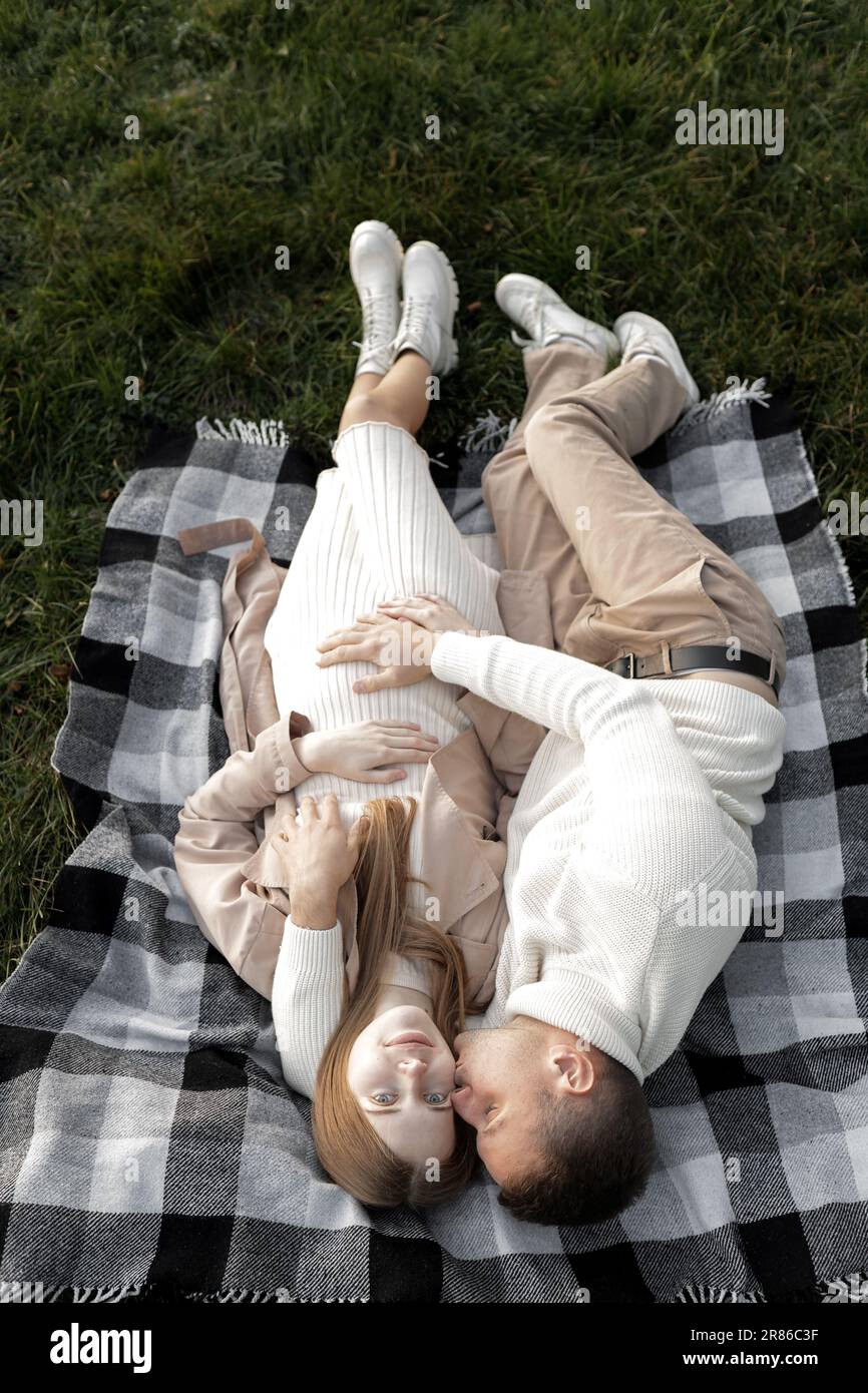 Happy family day. Top view of man and pregnant wife embrace and lie on ...