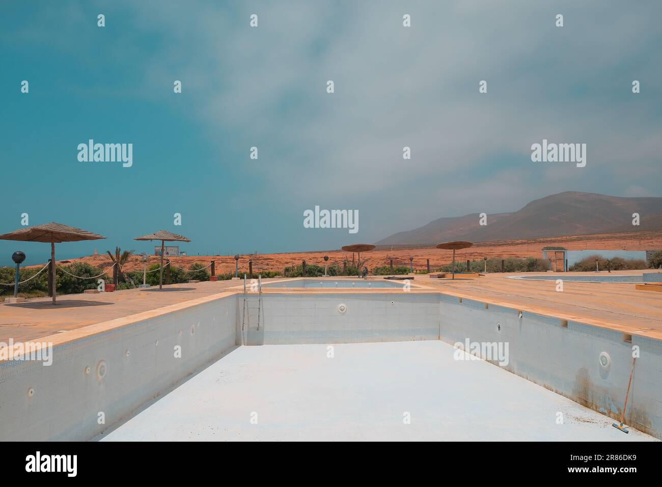 Large empty hotel swimming pool without water in Legzira, Morocco. Blue ...