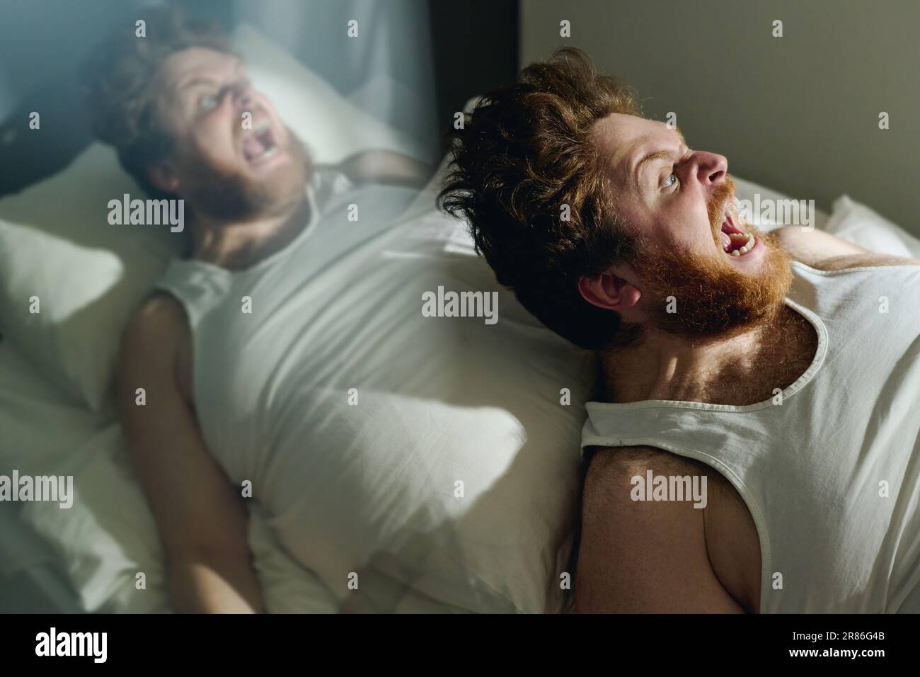 Double exposure of young mad man in vest screaming loudly in horror or ...