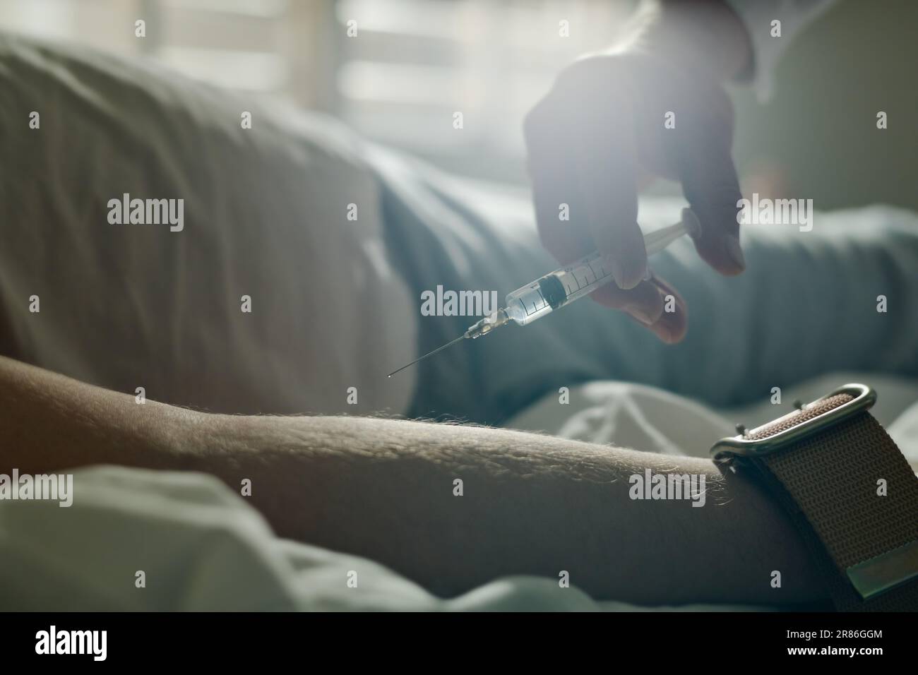 Hand of male doctor of mental hospital holding syringe with liquid ...