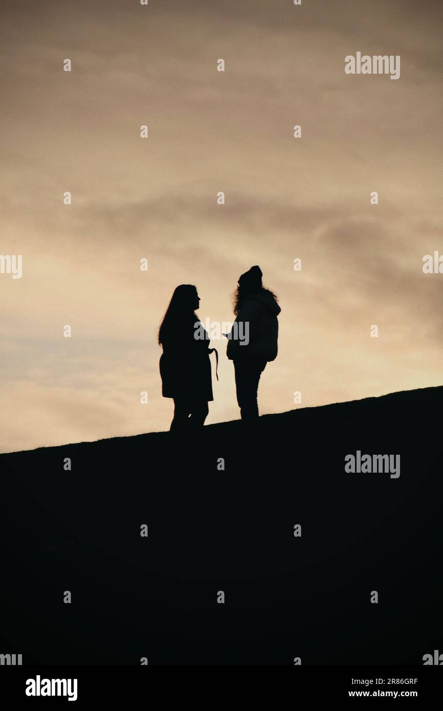 A silhouettes of people illuminated by a warm, golden light Stock Photo ...