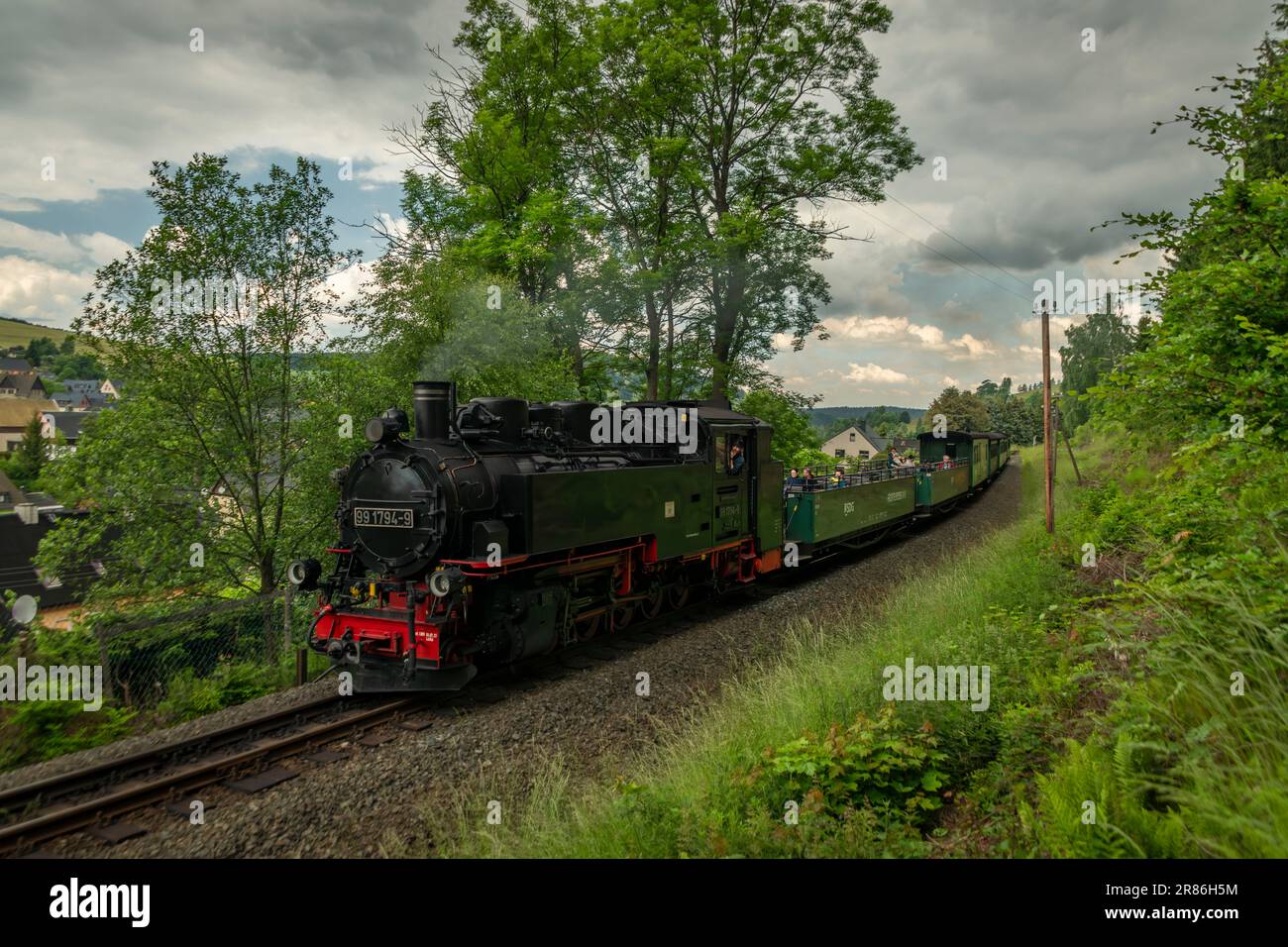 Steam engine train with passengers in fresh summer day near Neudorf ...