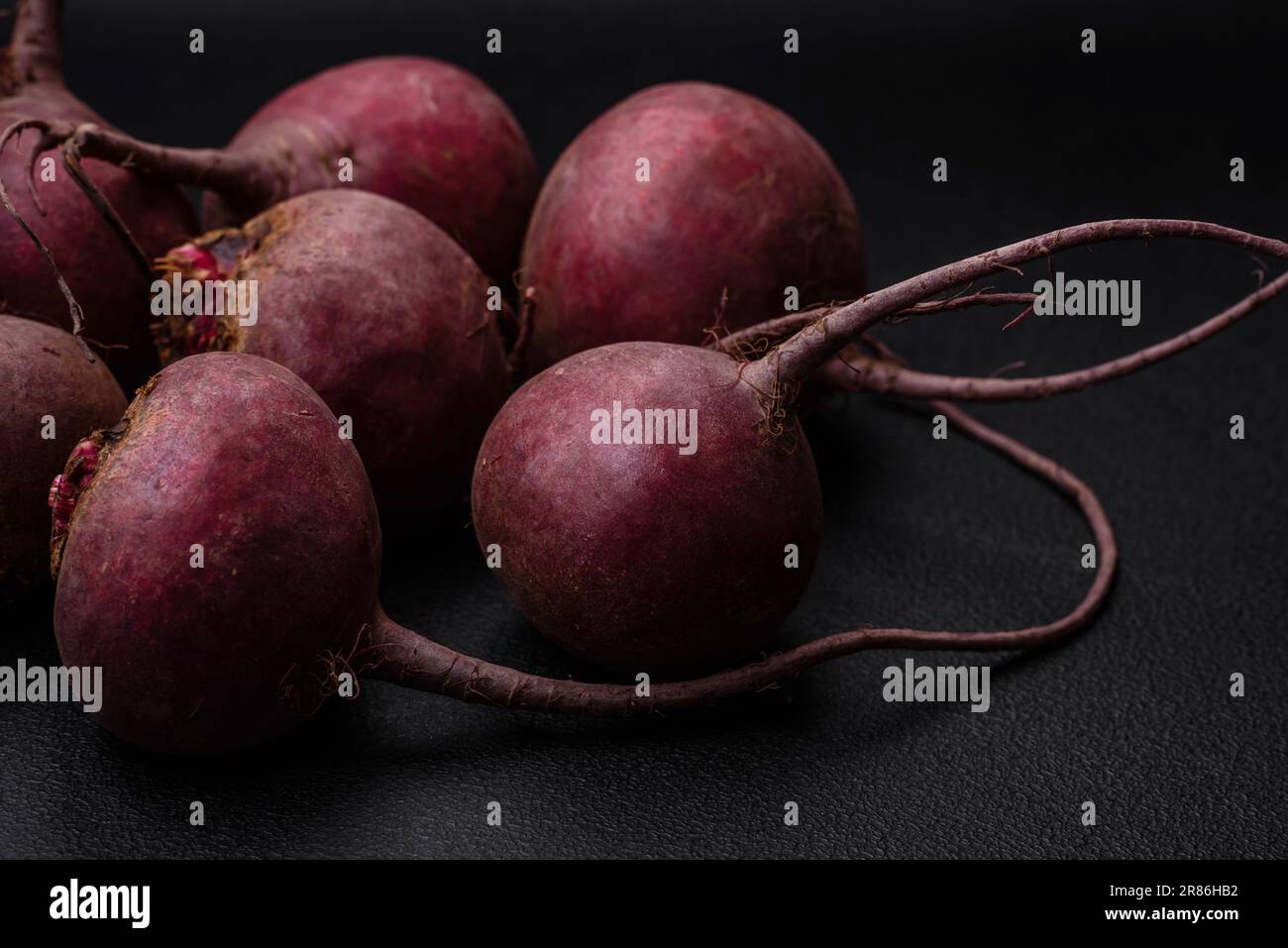 Fresh raw beetroot in the form of tubers on a textured concrete ...