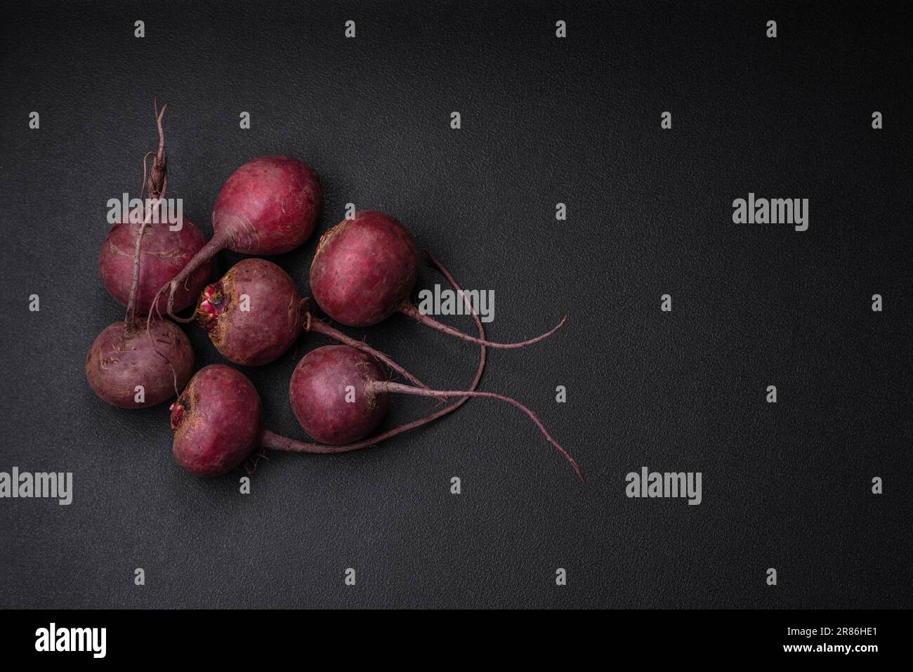 Fresh raw beetroot in the form of tubers on a textured concrete ...