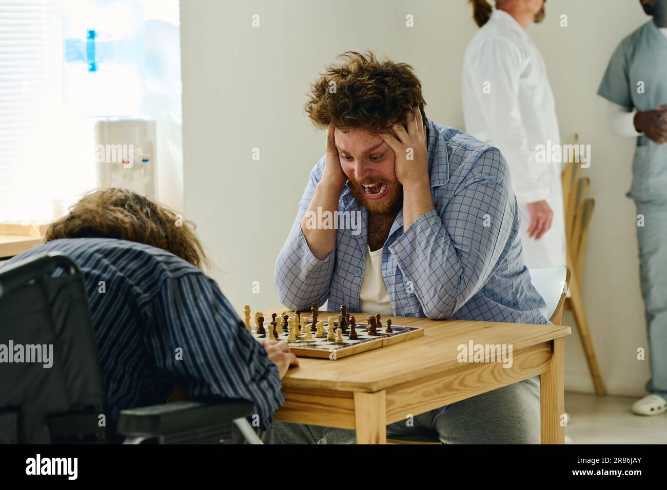 Nervous male patient of mental hospital touching head and screaming ...
