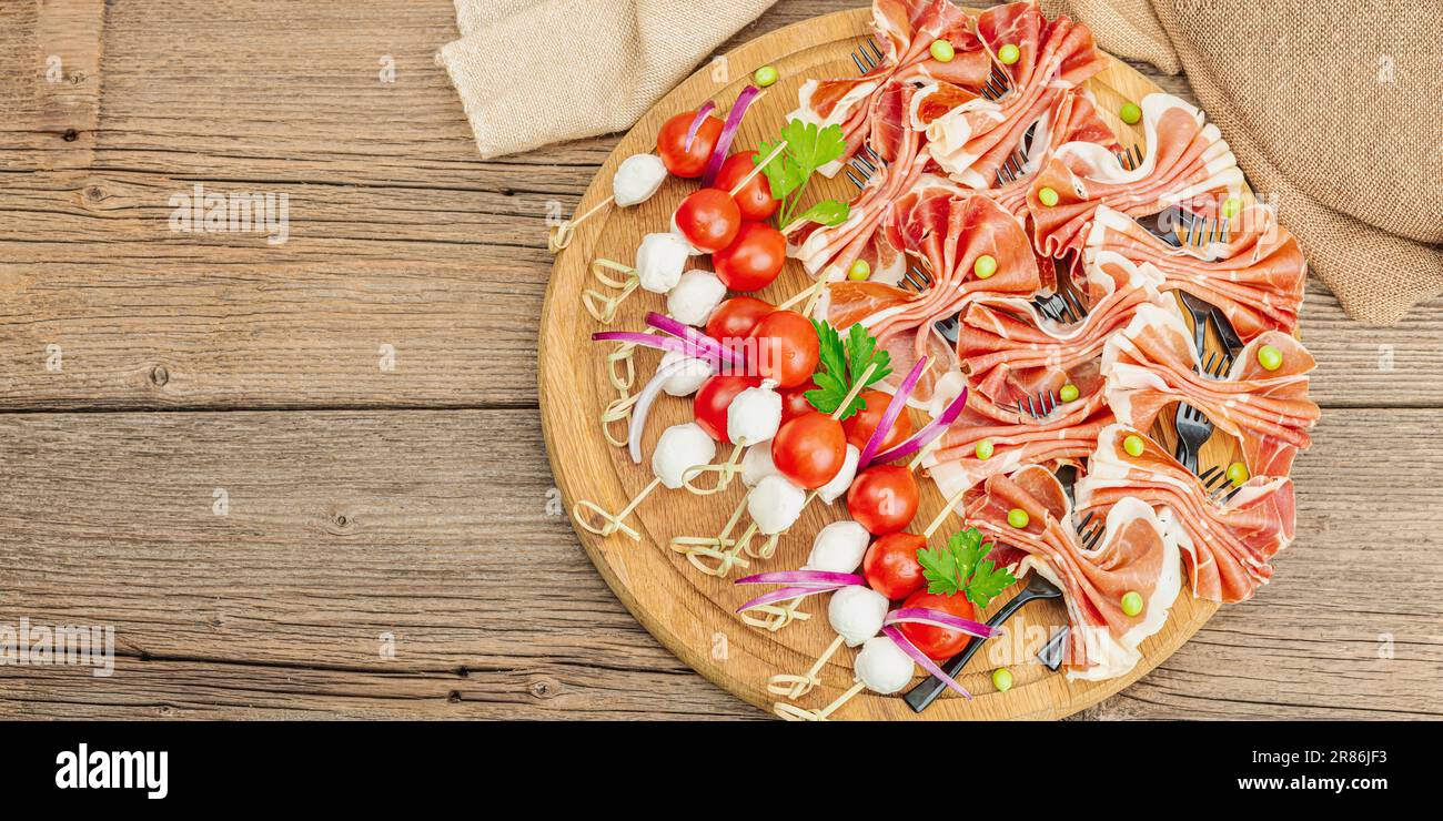 Set of picnic snacks on skewers. Jamon, mozzarella, cherry tomatoes ...