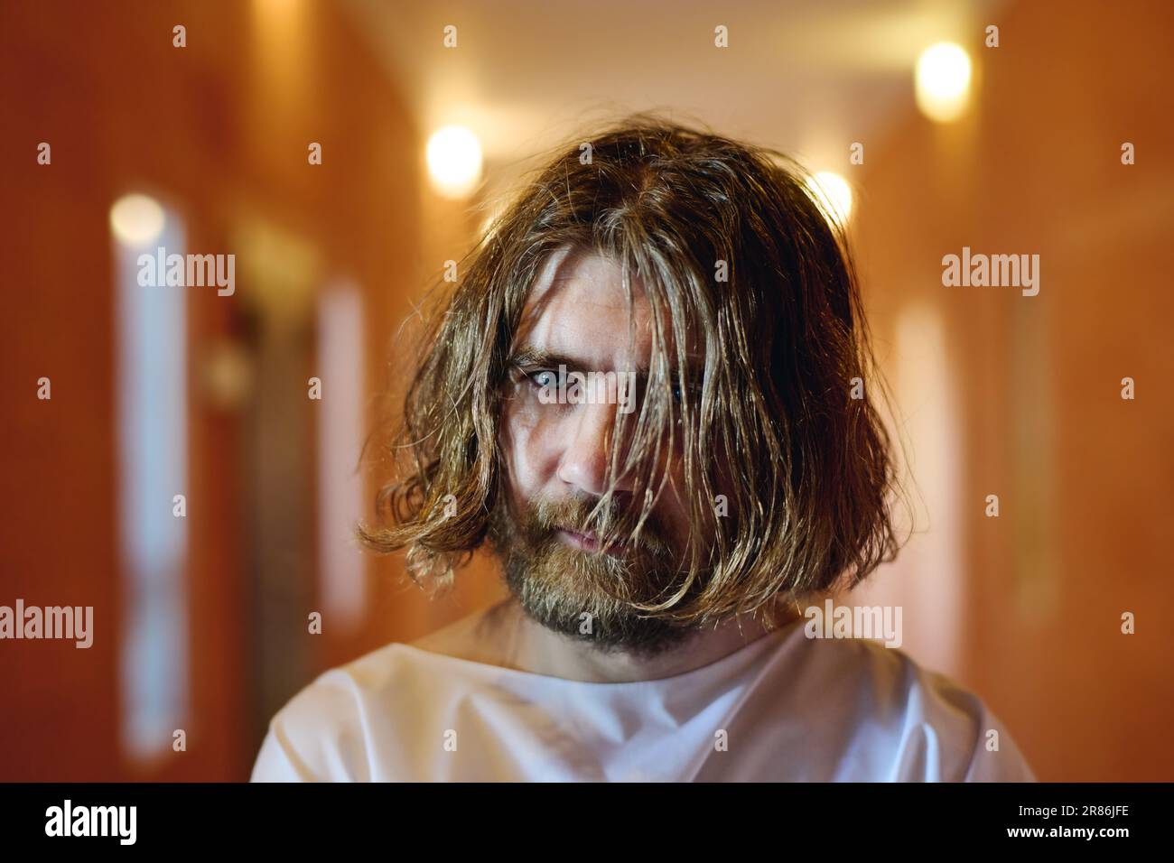 Young bearded male patient of mental hospital with long blond shaggy ...