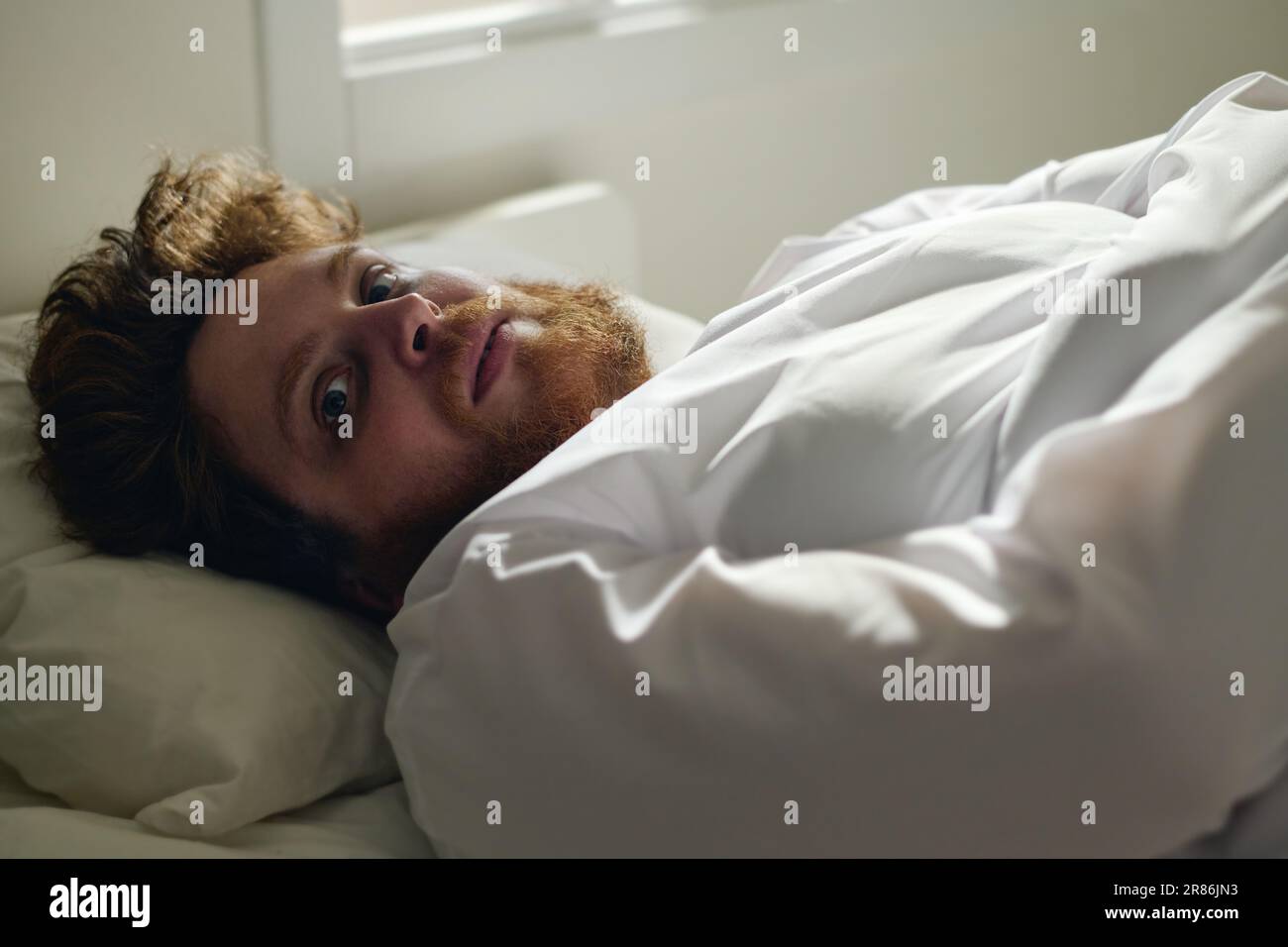 Young insane male patient of mental clinics looking at camera with ...