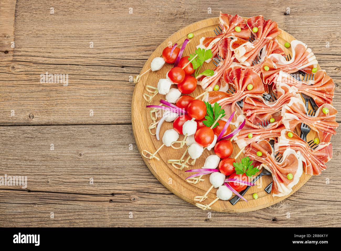Set of picnic snacks on skewers. Jamon, mozzarella, cherry tomatoes ...