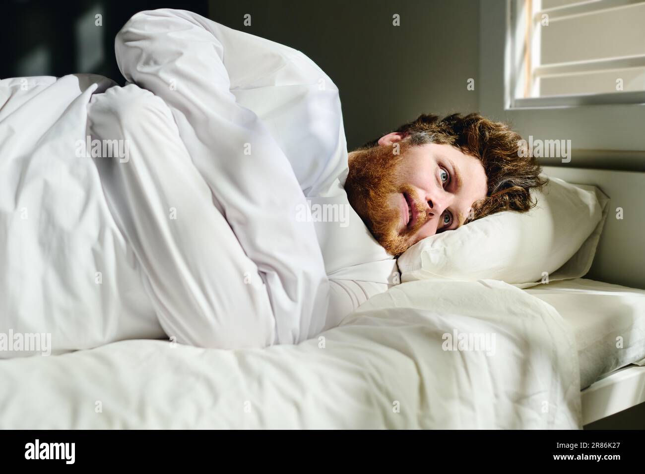 Young deranged man in straitjacket suffering from panic attack or ...