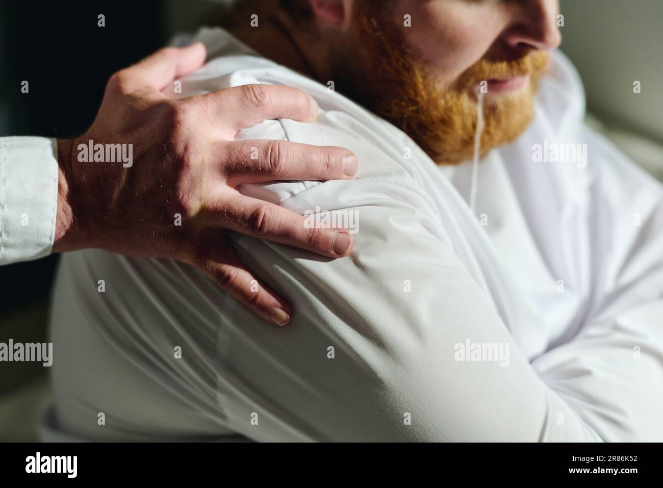 Hand of psychiatrist of mental hospital on shoulder of male patient in ...