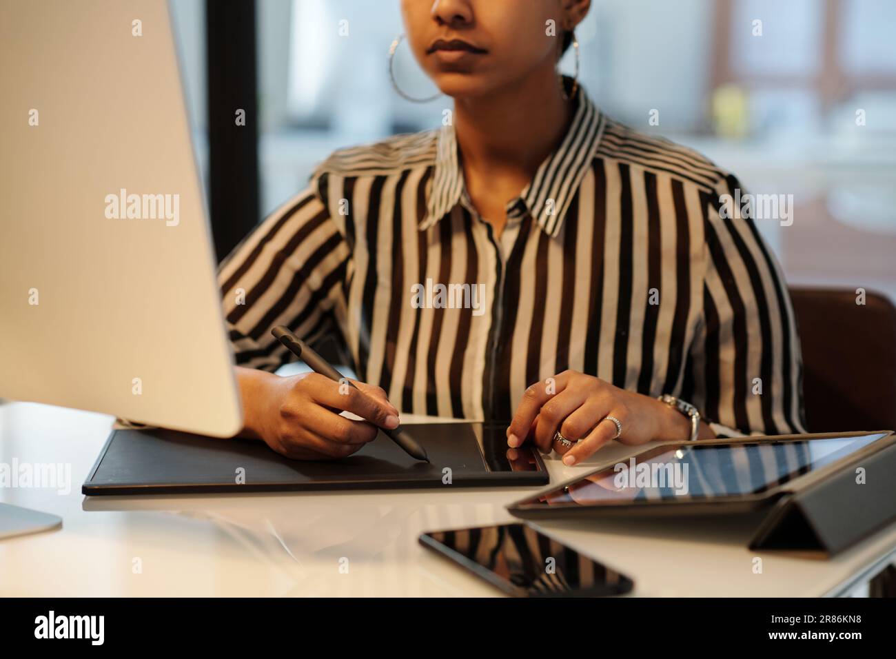 Hands of young female graphic designer with stylus and touchpad sitting ...