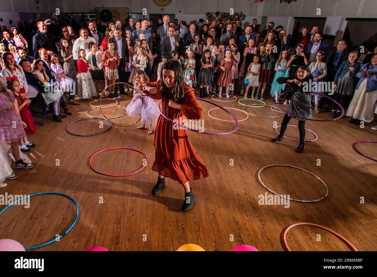 Middle school students spin hula hoops at a fathers and daughters dance ...