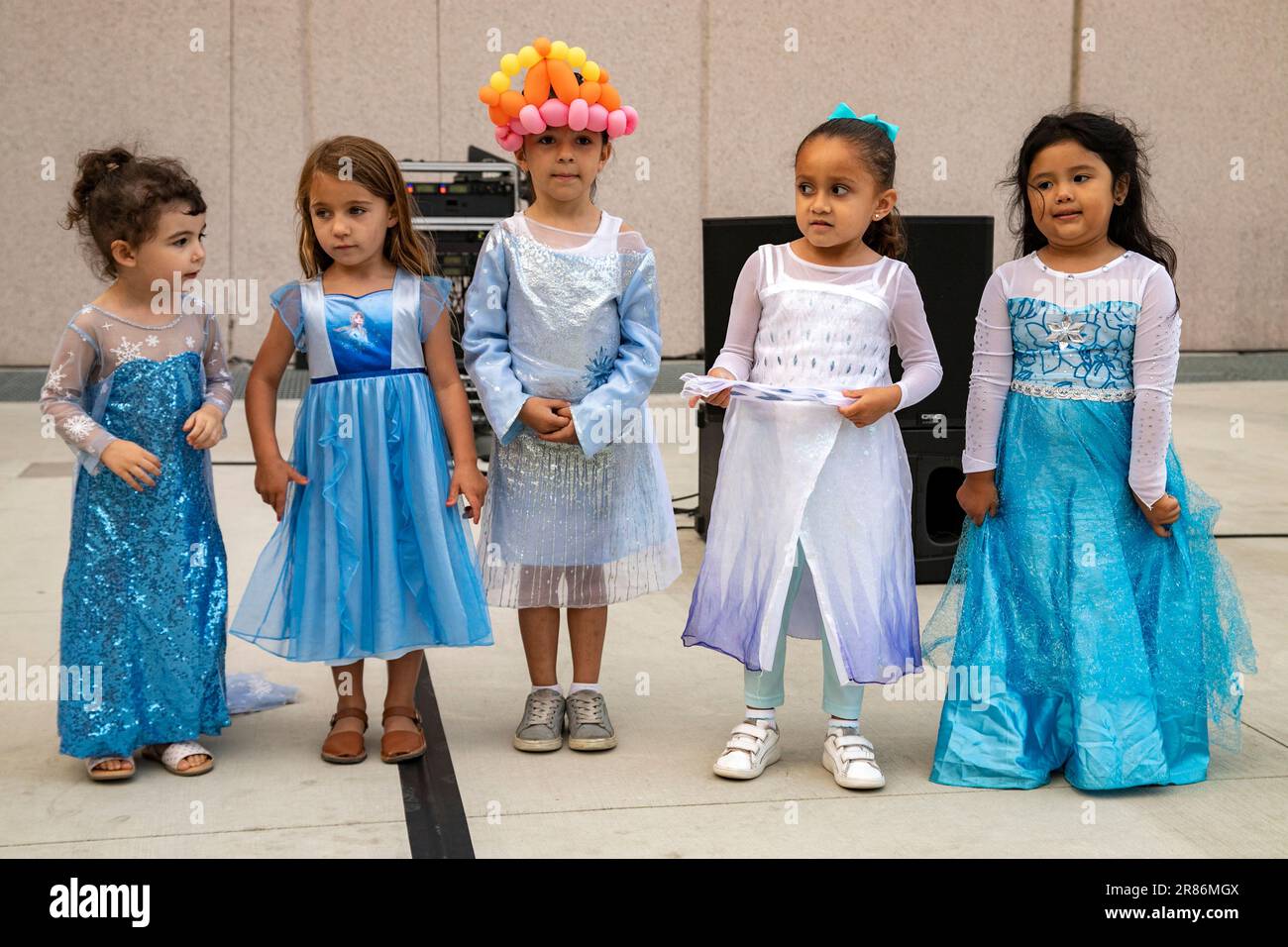 Wearing formal clothes, five multiracial little girls line up on an ...