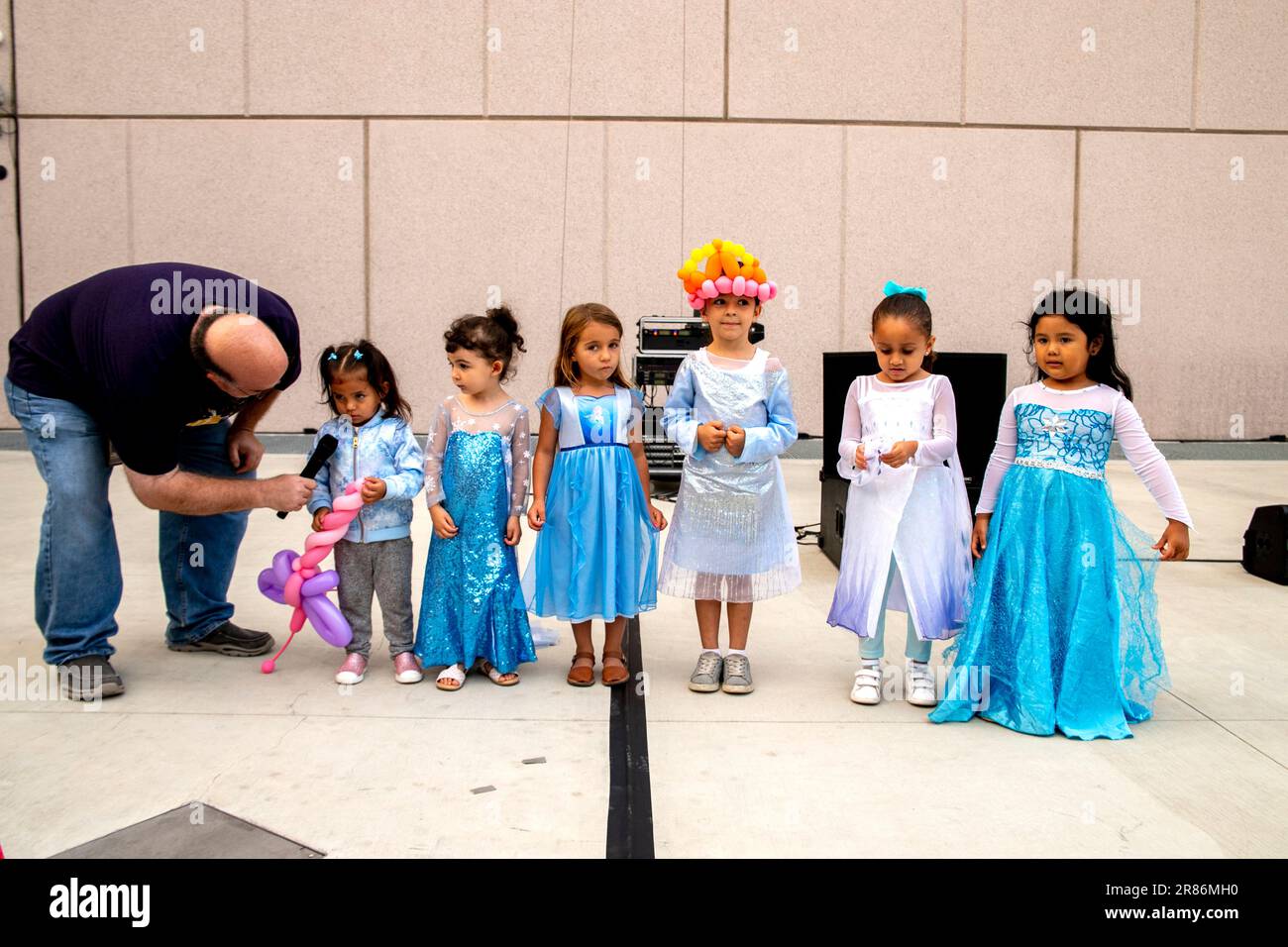 Wearing formal clothes, six multiracial little girls line up on an ...
