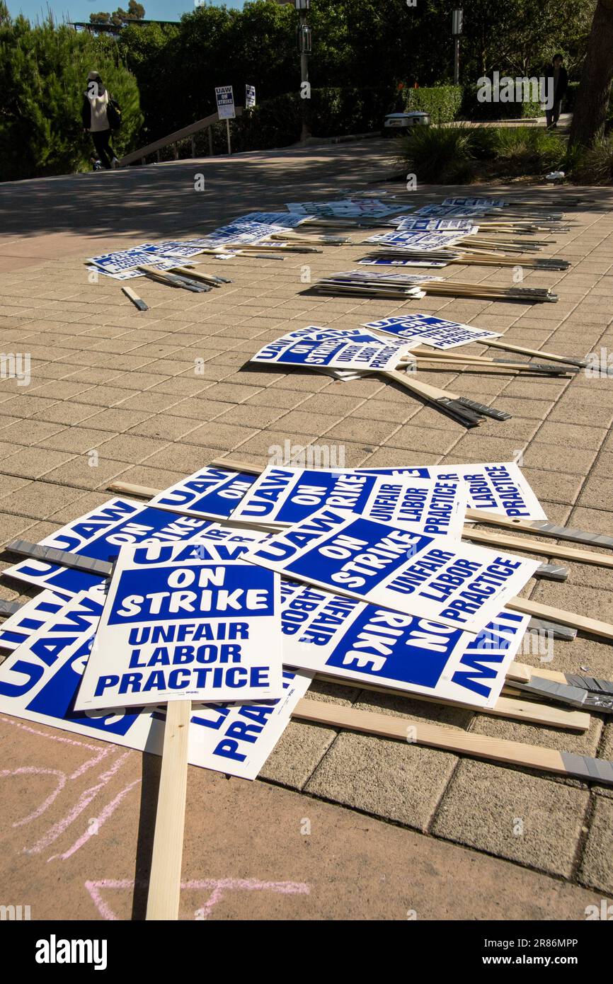 Signs for graduate students striking for higher wages are piled on a ...