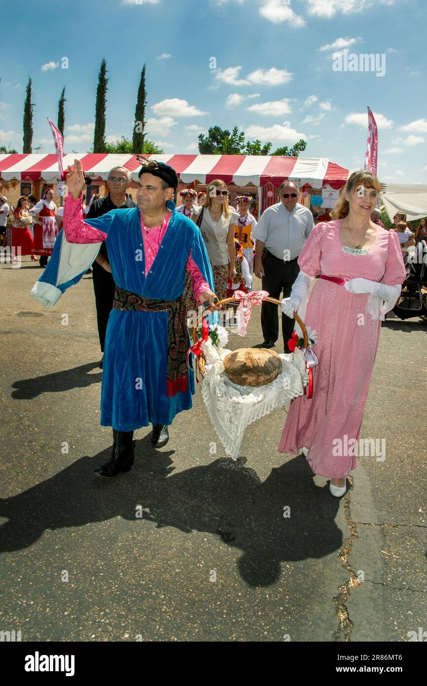 Costumed as the Lord and Lady of the manor, a couple carries a large ...