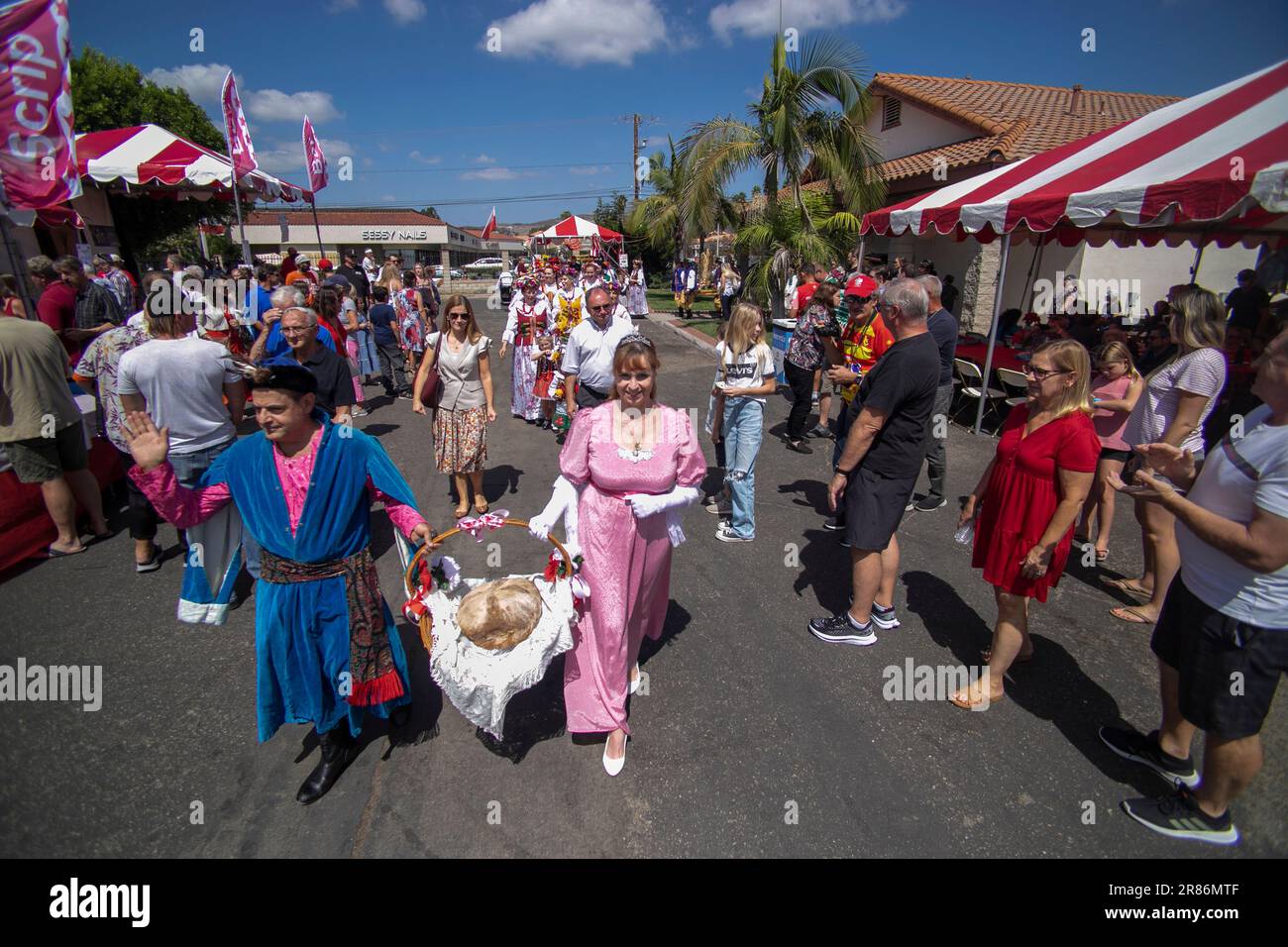 Costumed as the Lord and Lady of the manor, a couple carries a large ...