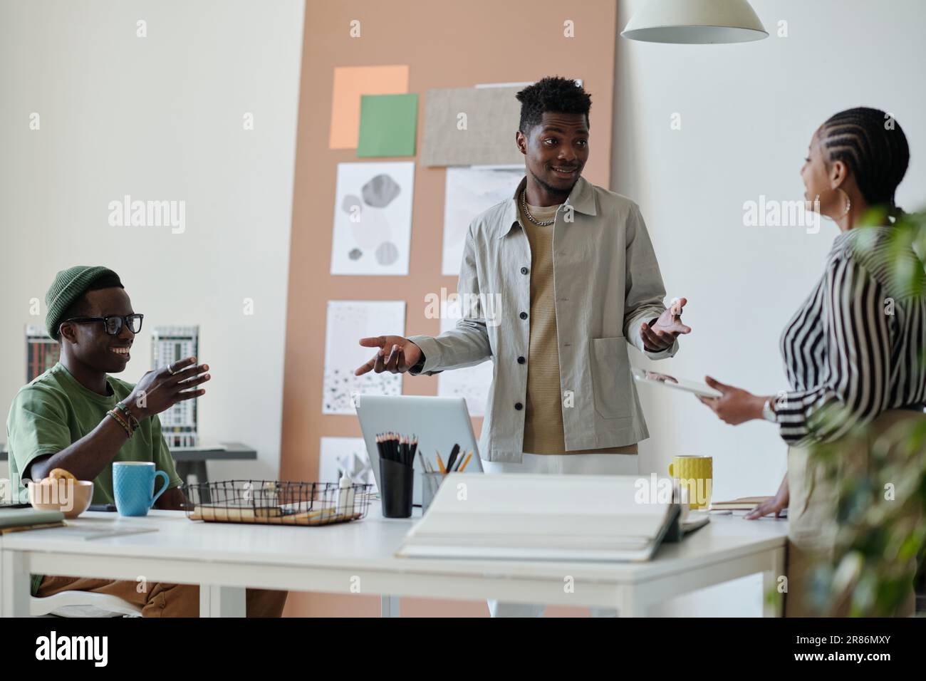 Young confident African American designer explaining something to ...