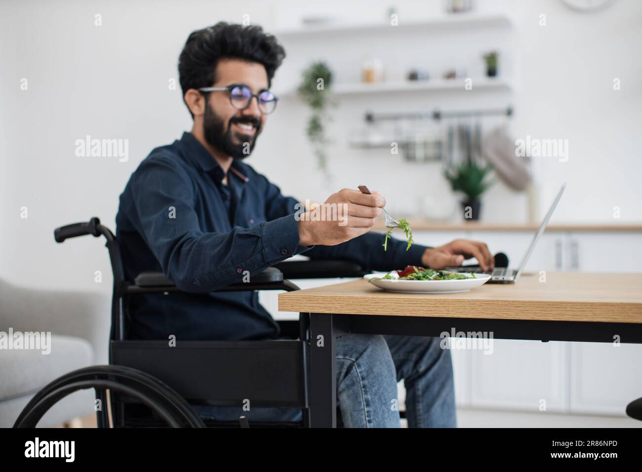 Focus on mixture salad placed on writing desk near laptop by indian ...