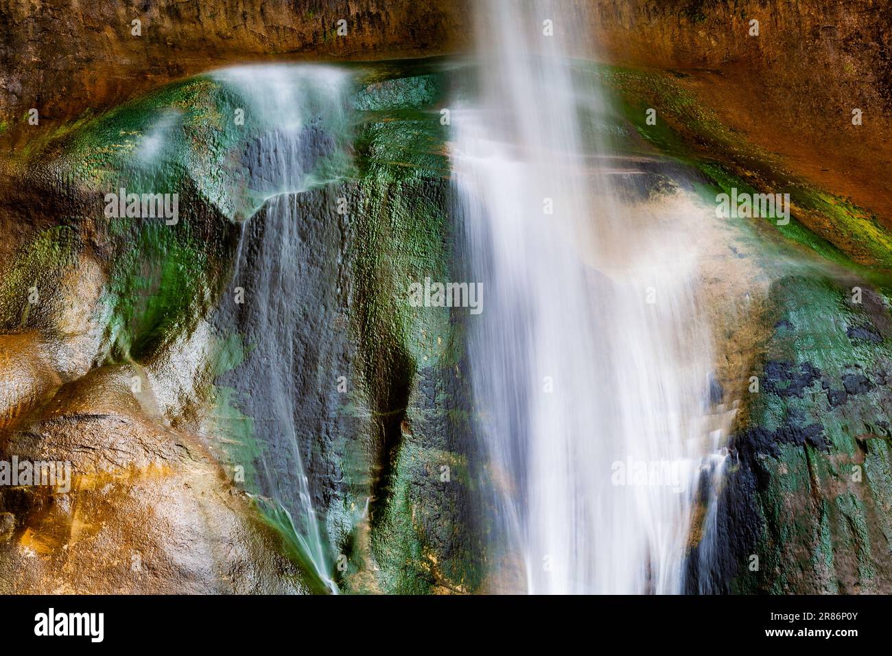Waterfall in the foreground, with flowing water. Upper Calf Creek Falls ...