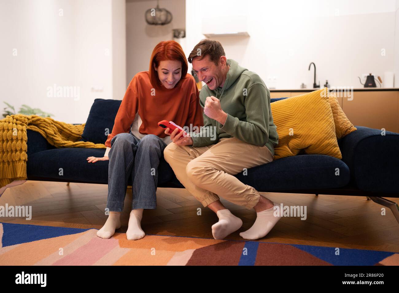 Happy excited family couple look at smartphone screen feeling overjoyed ...