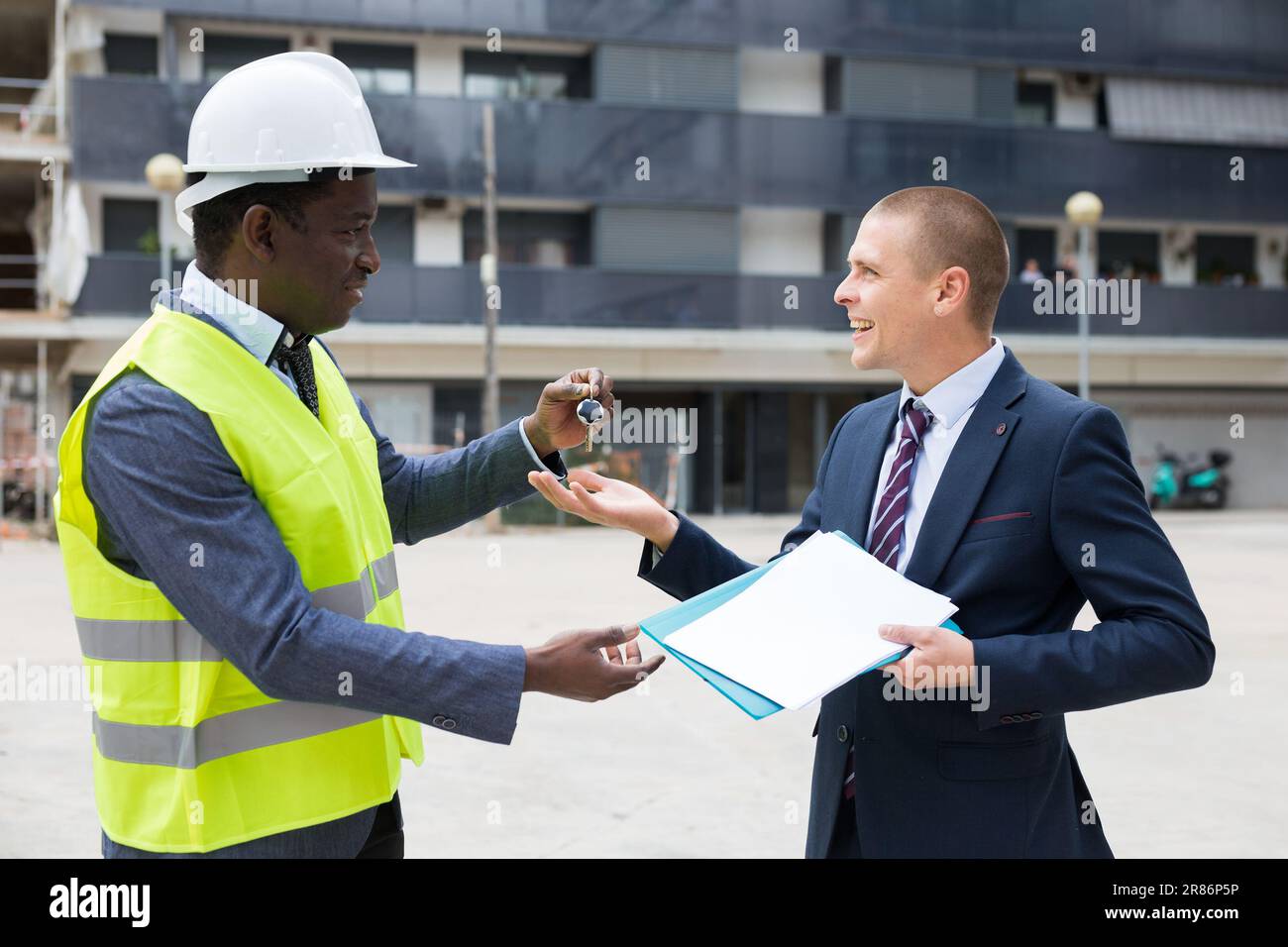 African-american contractor hands the keys to a man customer Stock ...