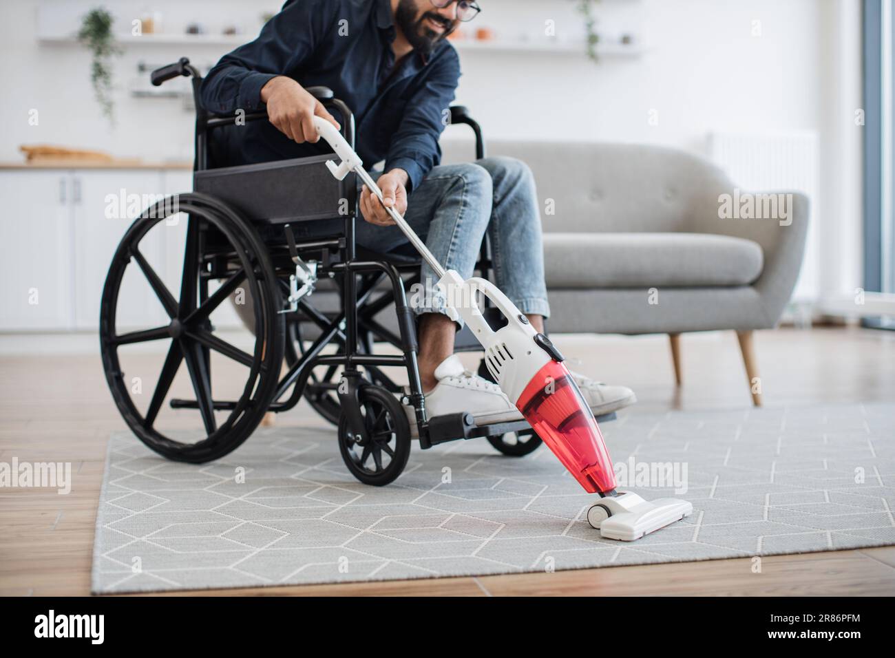 Cropped view of smiling man with mobility impairment handling debris on ...