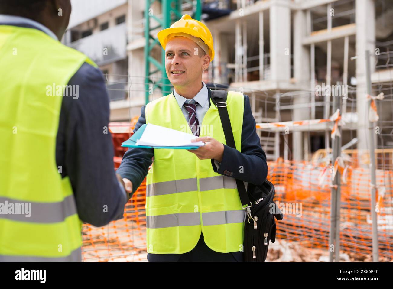 Two confident civil engineers exchange a friendly handshake Stock Photo ...