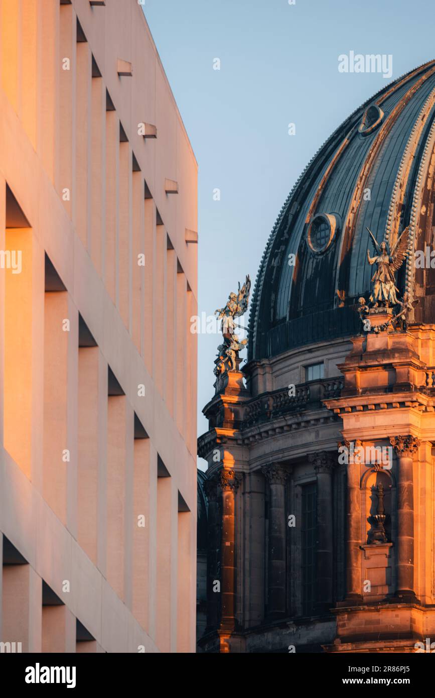A traditional analog clock mounted on the exterior wall of a high-rise ...