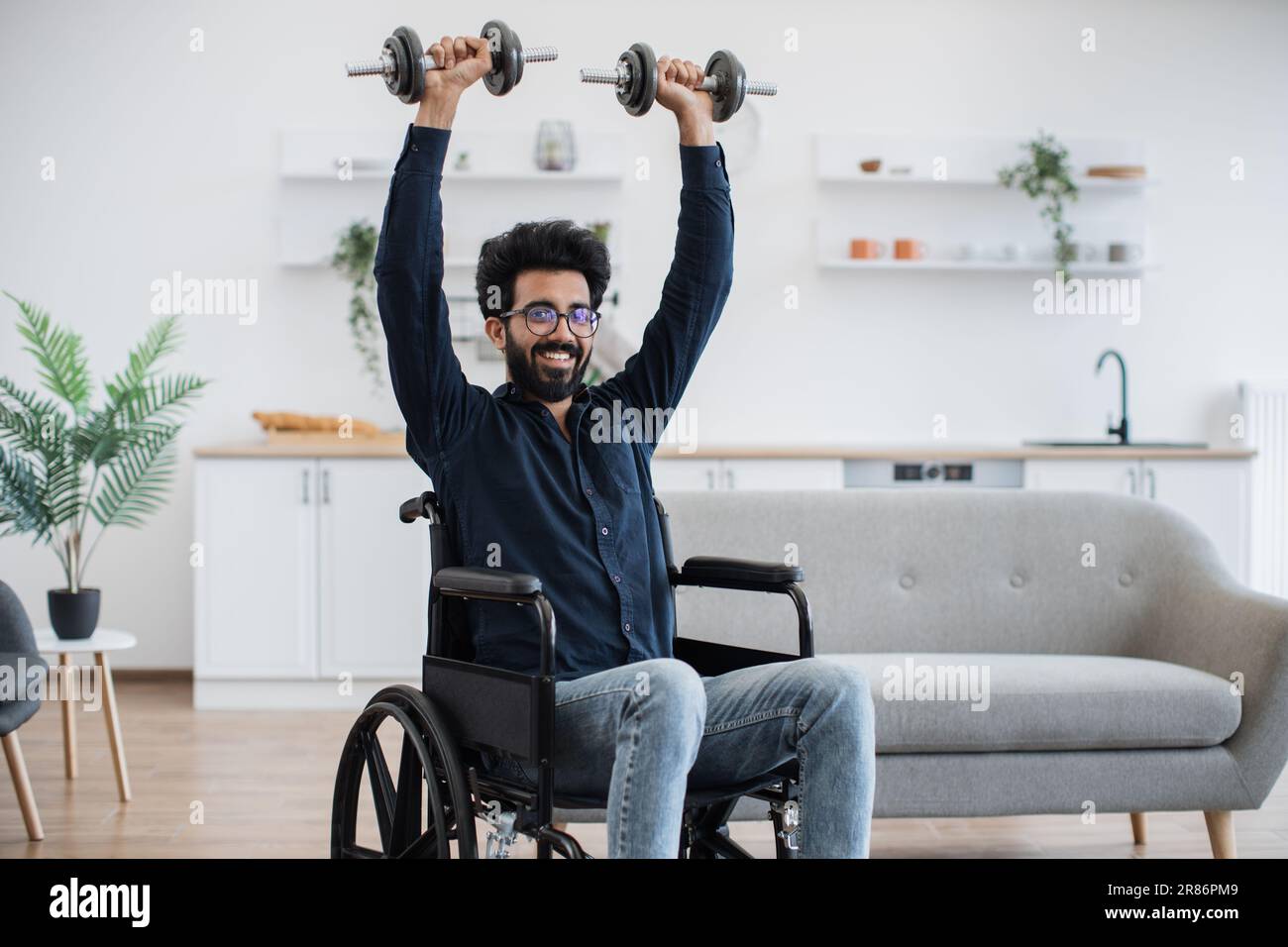 Person with disability raising dumbbells in kitchen interior Stock ...