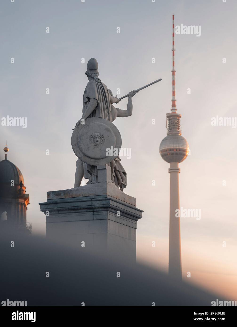 A majestic statue of a figure holding a sword stands in front of a ...