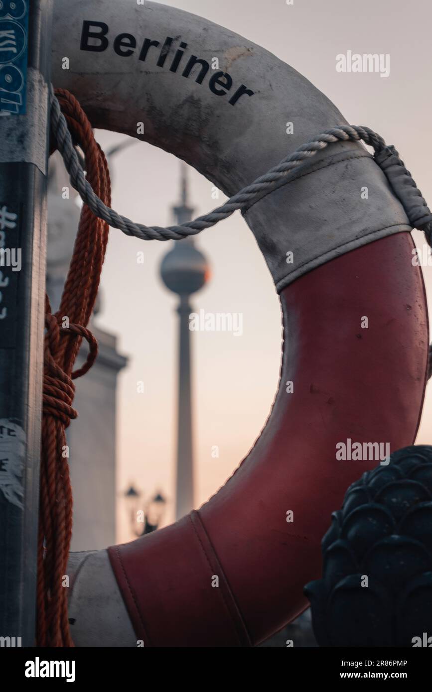 A life preserver hangs from a tall tower in a body of water Stock Photo ...