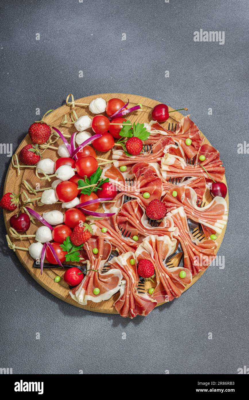 Set of picnic snacks on skewers. Jamon, mozzarella, cherry tomatoes ...