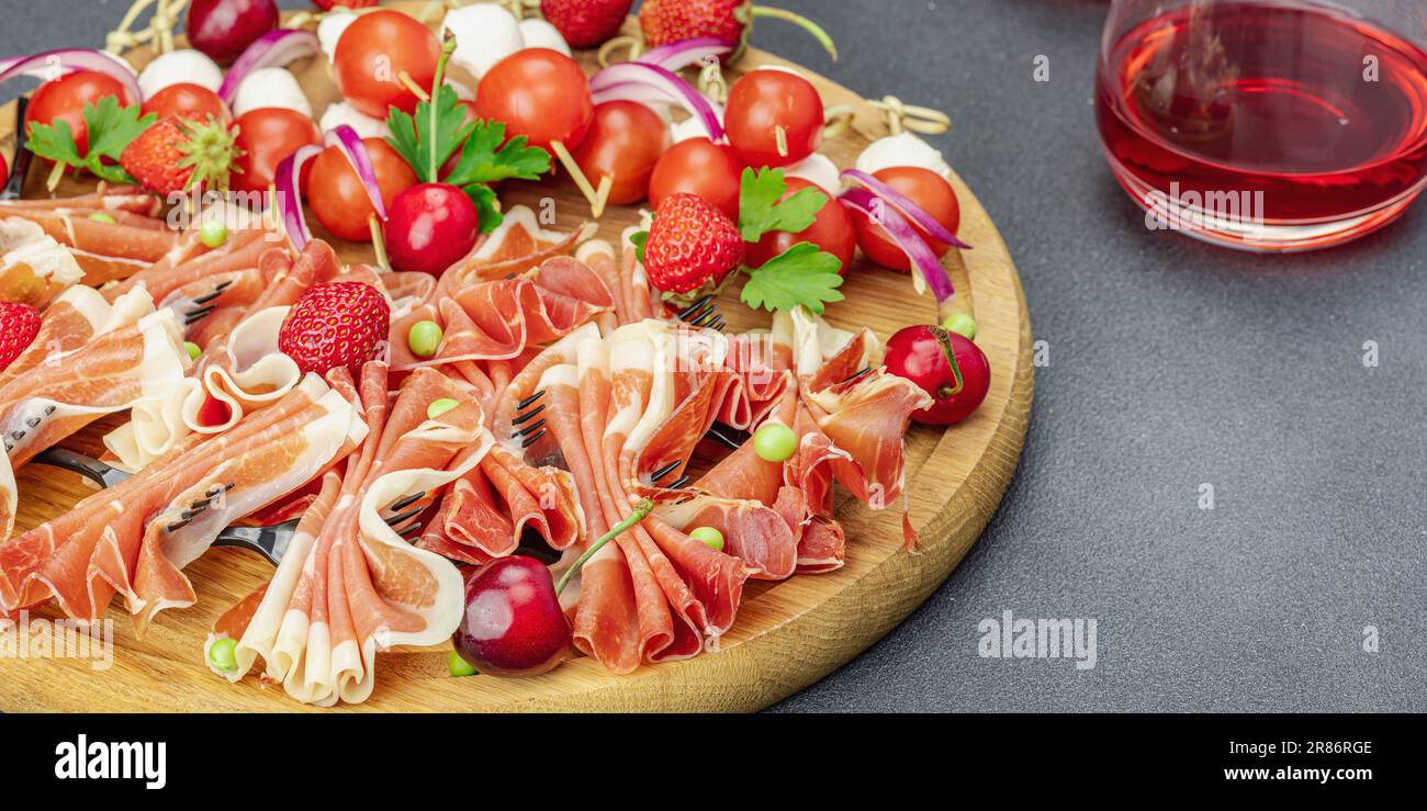 Set of picnic snacks on skewers. Jamon, mozzarella, cherry tomatoes ...