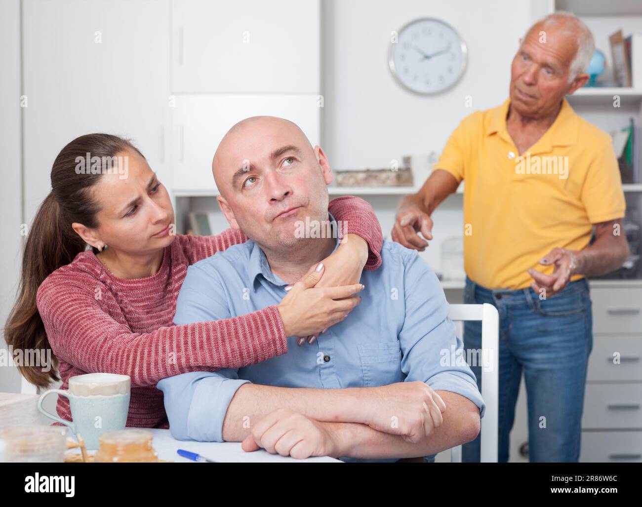 Wife calms husband after his quarrel with father Stock Photo - Alamy