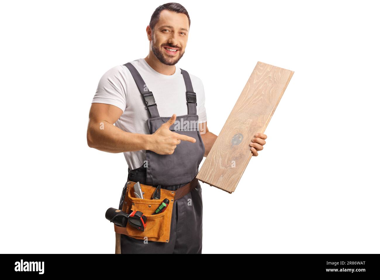 Carpenter holding a wooden floor beam and pointing isolated on white ...