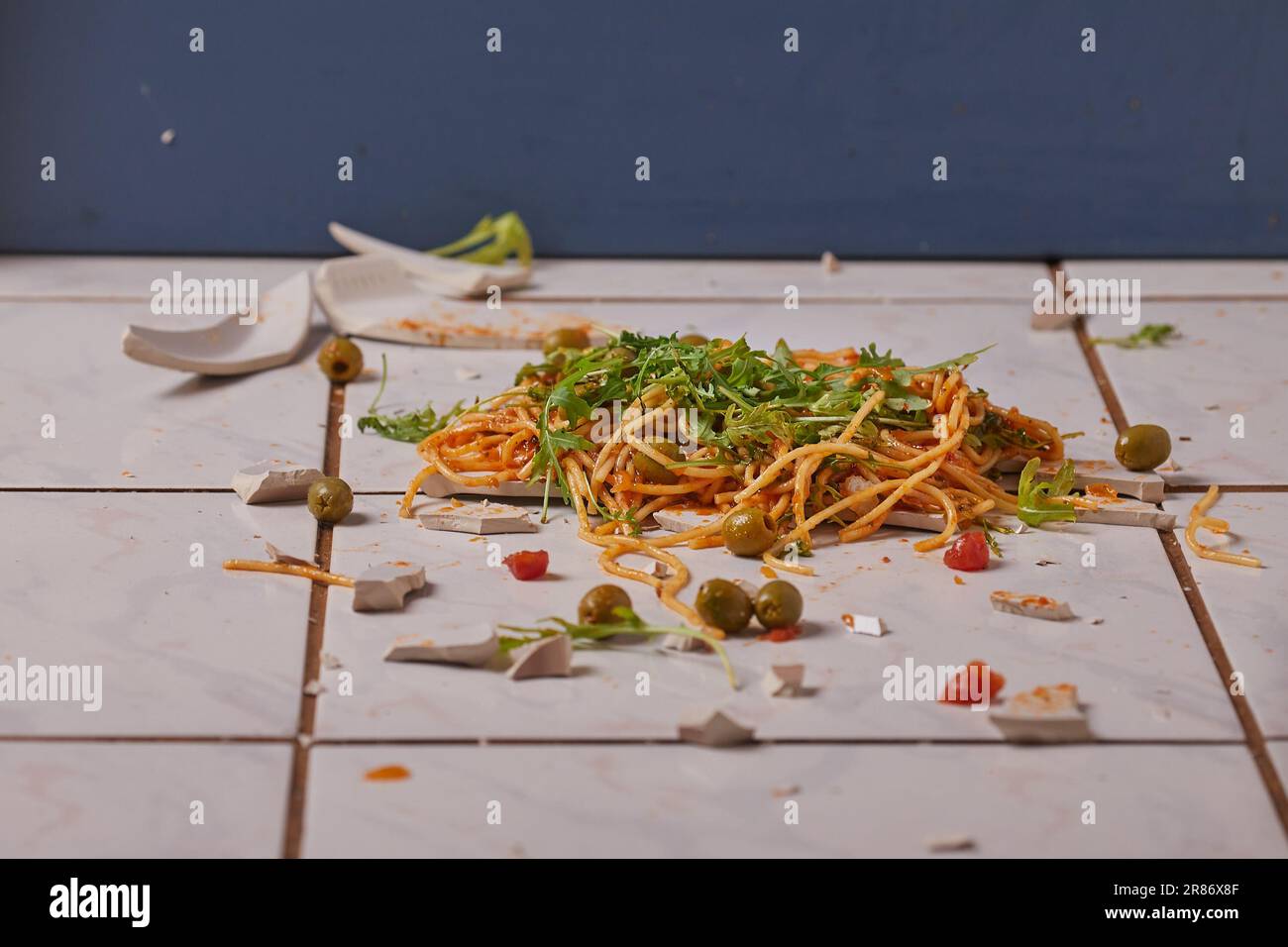 Fallen plate of pasta in the kitchen floor Stock Photo - Alamy