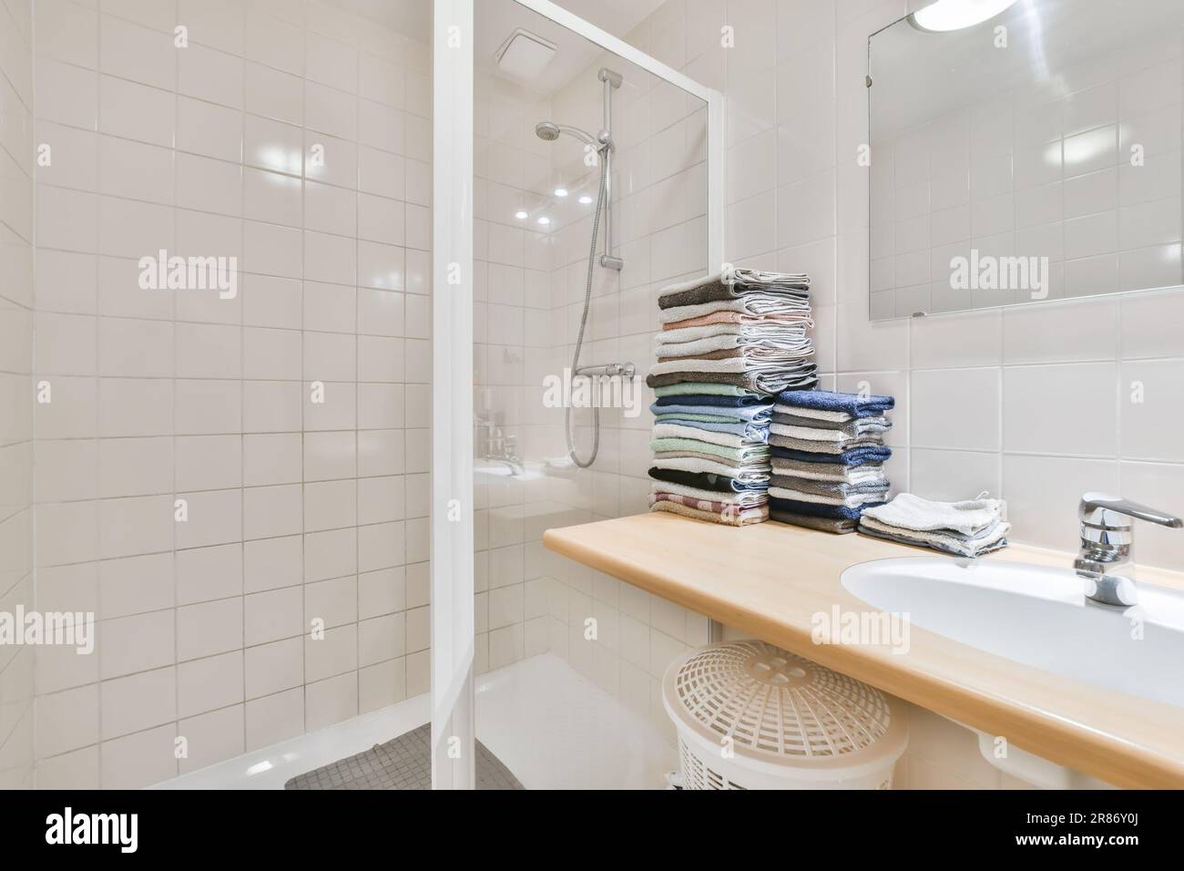 a bathroom with white tiles on the walls, and a wooden counter in the ...