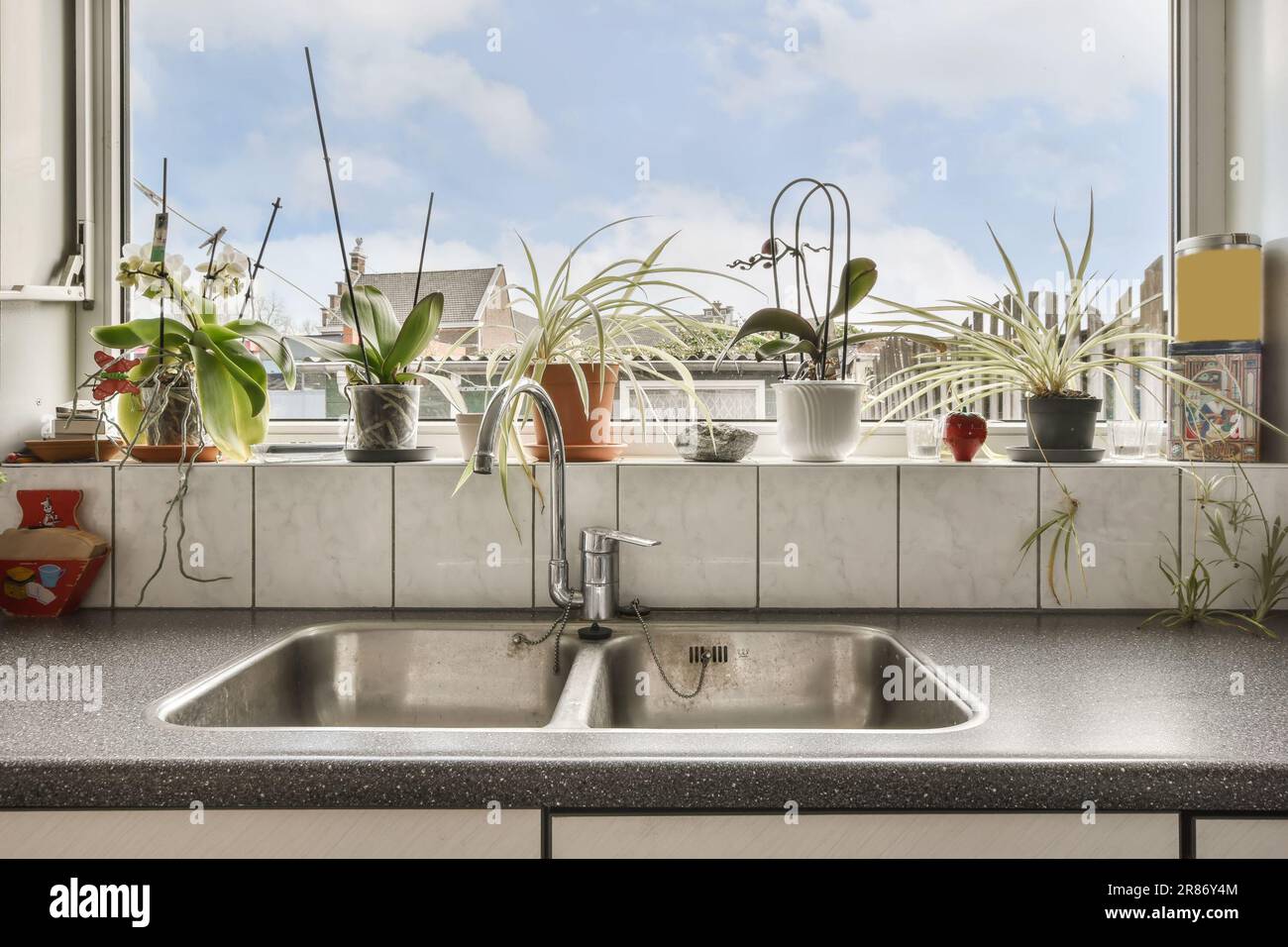 a kitchen sink with plants in pots on the window sie above it is a view ...