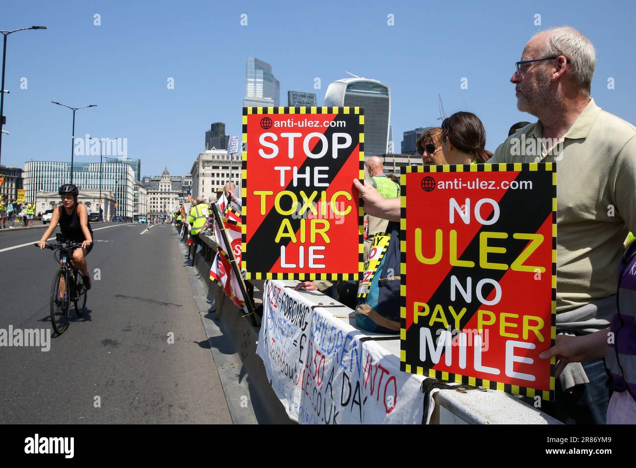 London, UK. 27th May, 2023. Anti ULEZ campaigners hold signs expressing ...