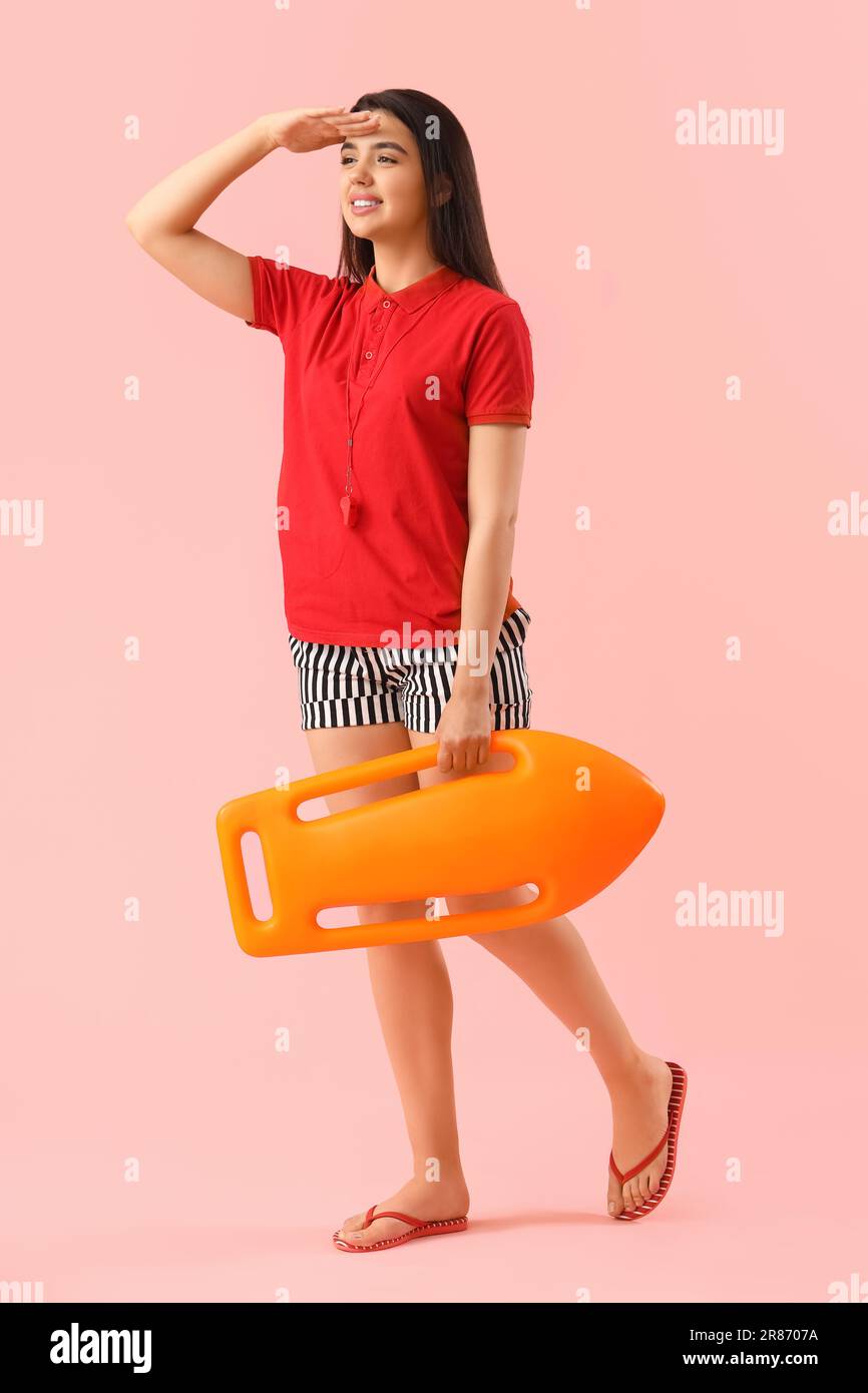 Female lifeguard with board on pink background Stock Photo - Alamy