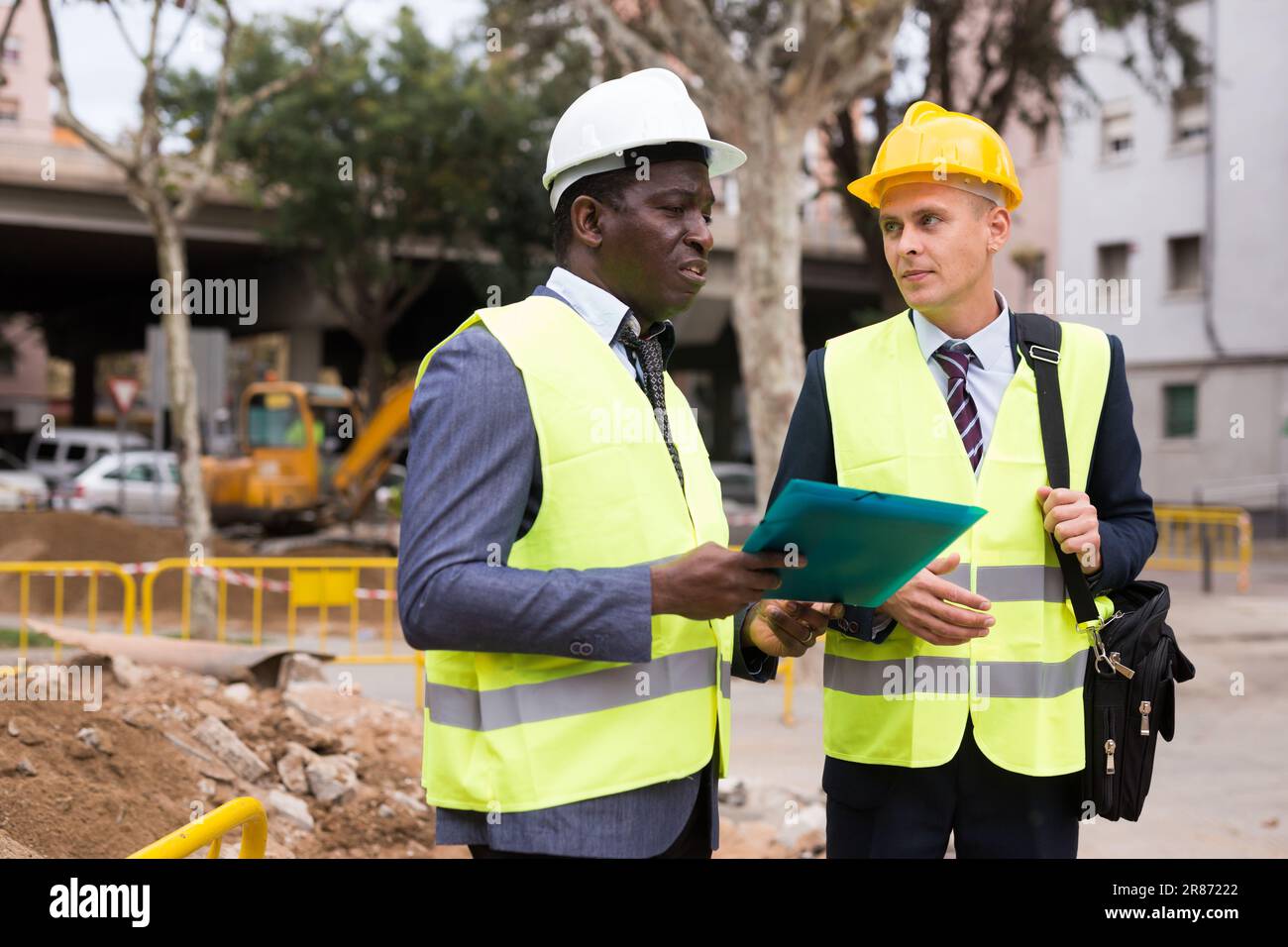 Engineer and architect are discussing options for laying a pipe on ...