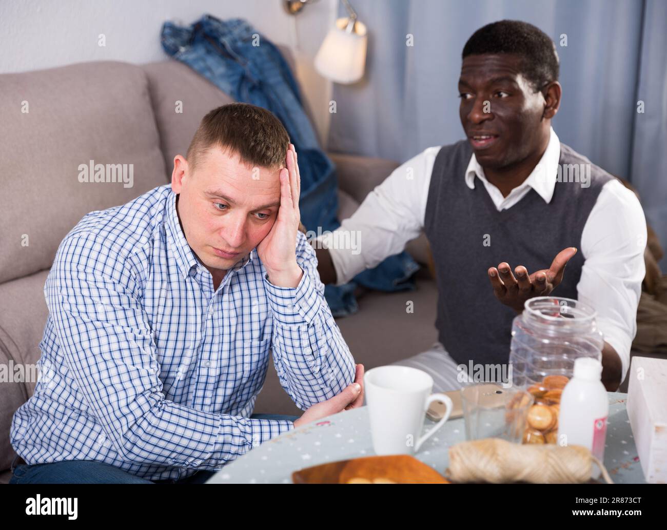 African man calming friend after dispute Stock Photo - Alamy